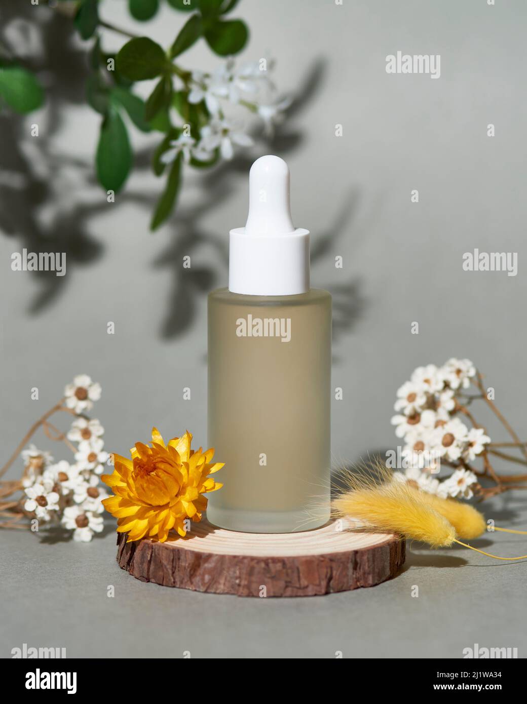 Glass bottle with organic hyaluronic acid placed on wooden board near ...