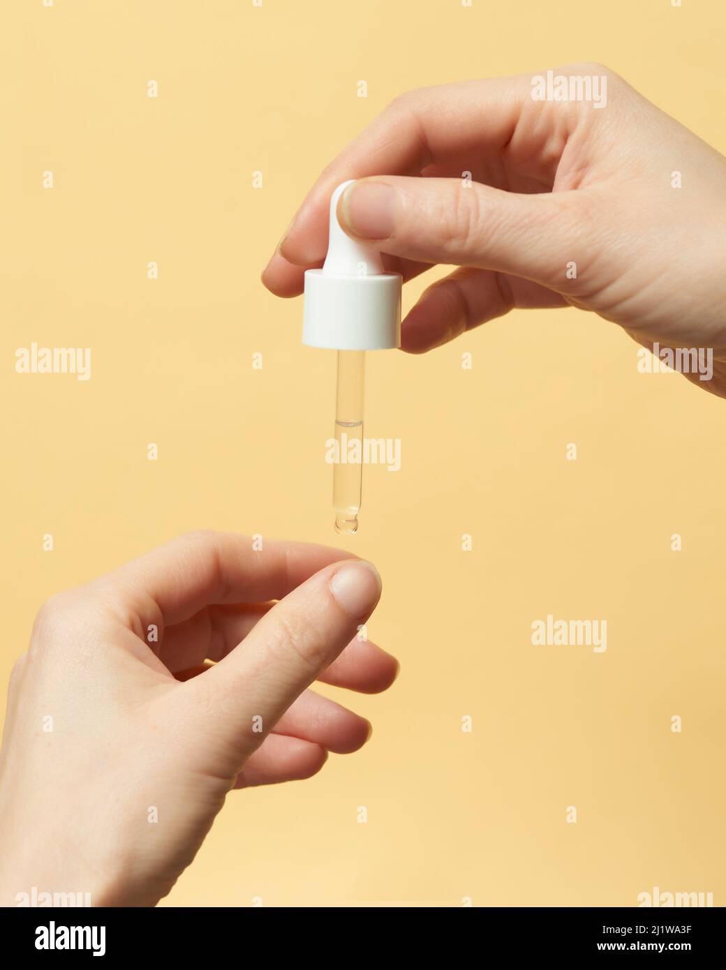 Hands of crop anonymous person dripping hyaluronic acid from pipette on ...