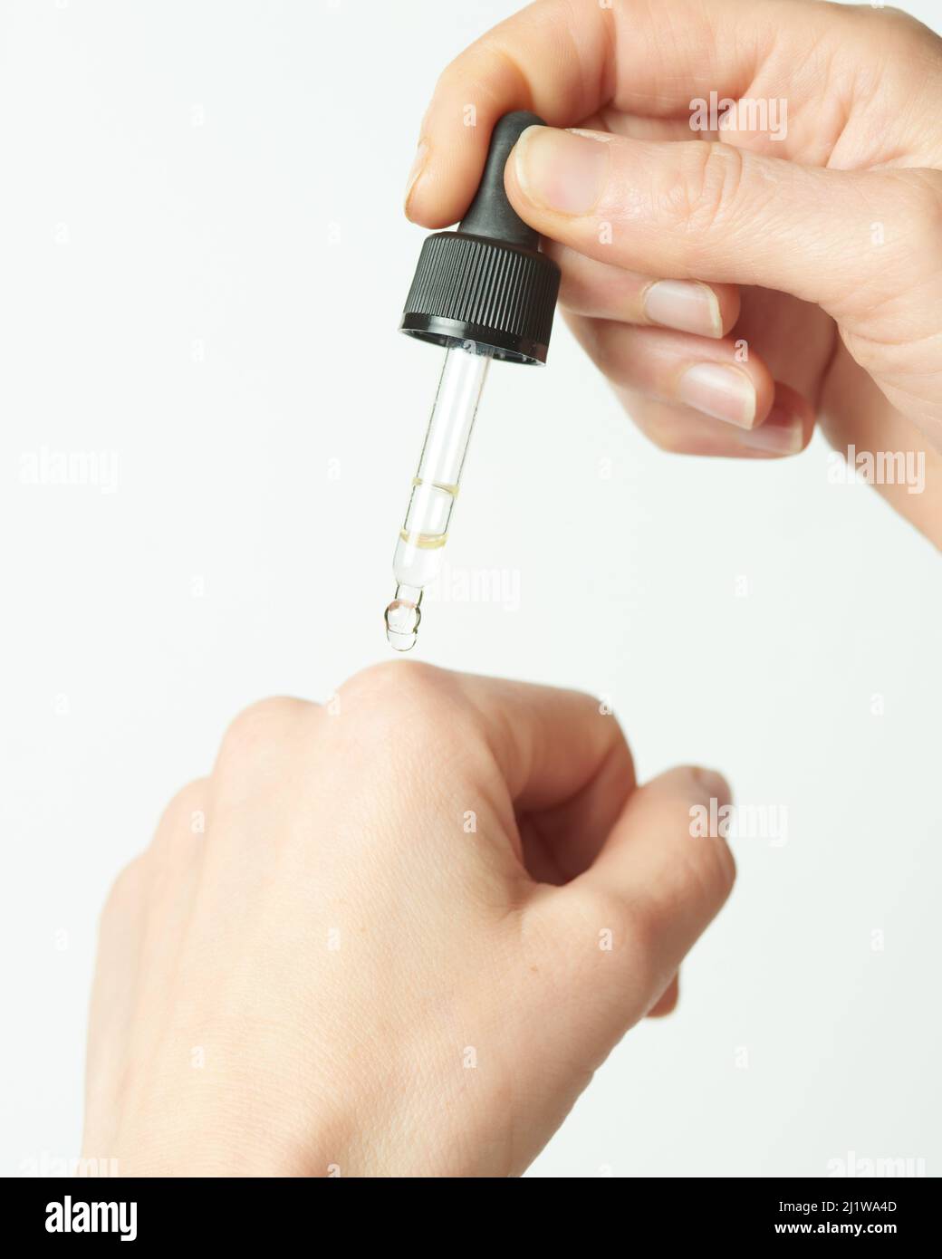Hands of crop anonymous person dripping hyaluronic acid from pipette on ...