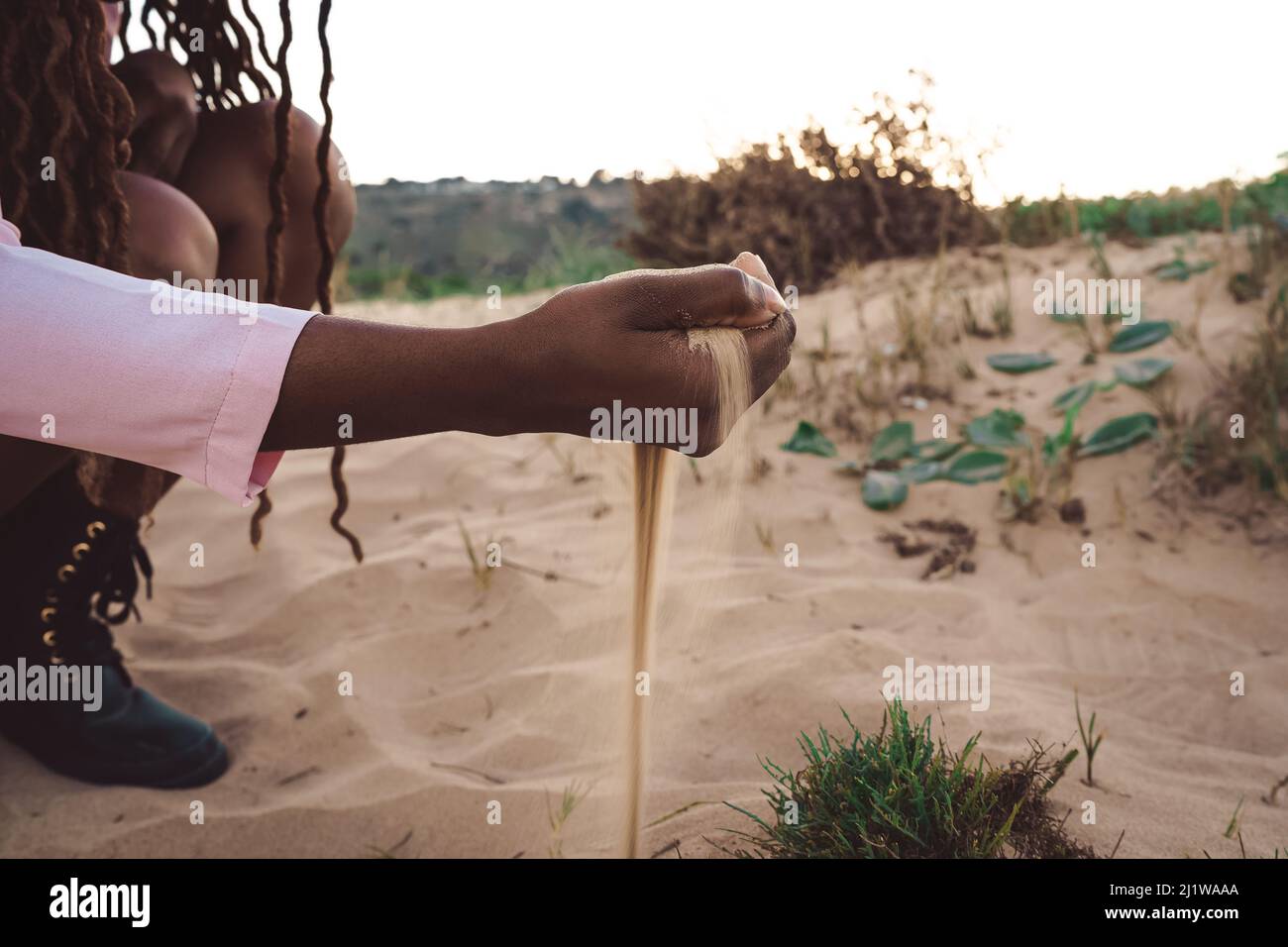 Side view of crop unrecognizable African American female with sand ...