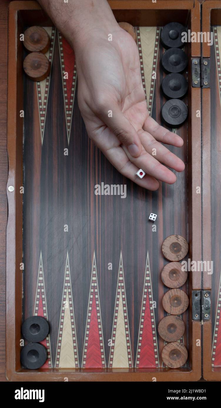 Close up woman hand holding backgammon dices and playing backgammon at ...