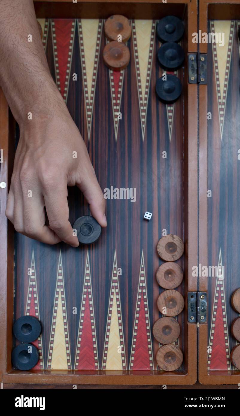 Close up woman hand holding backgammon dices and playing backgammon at ...
