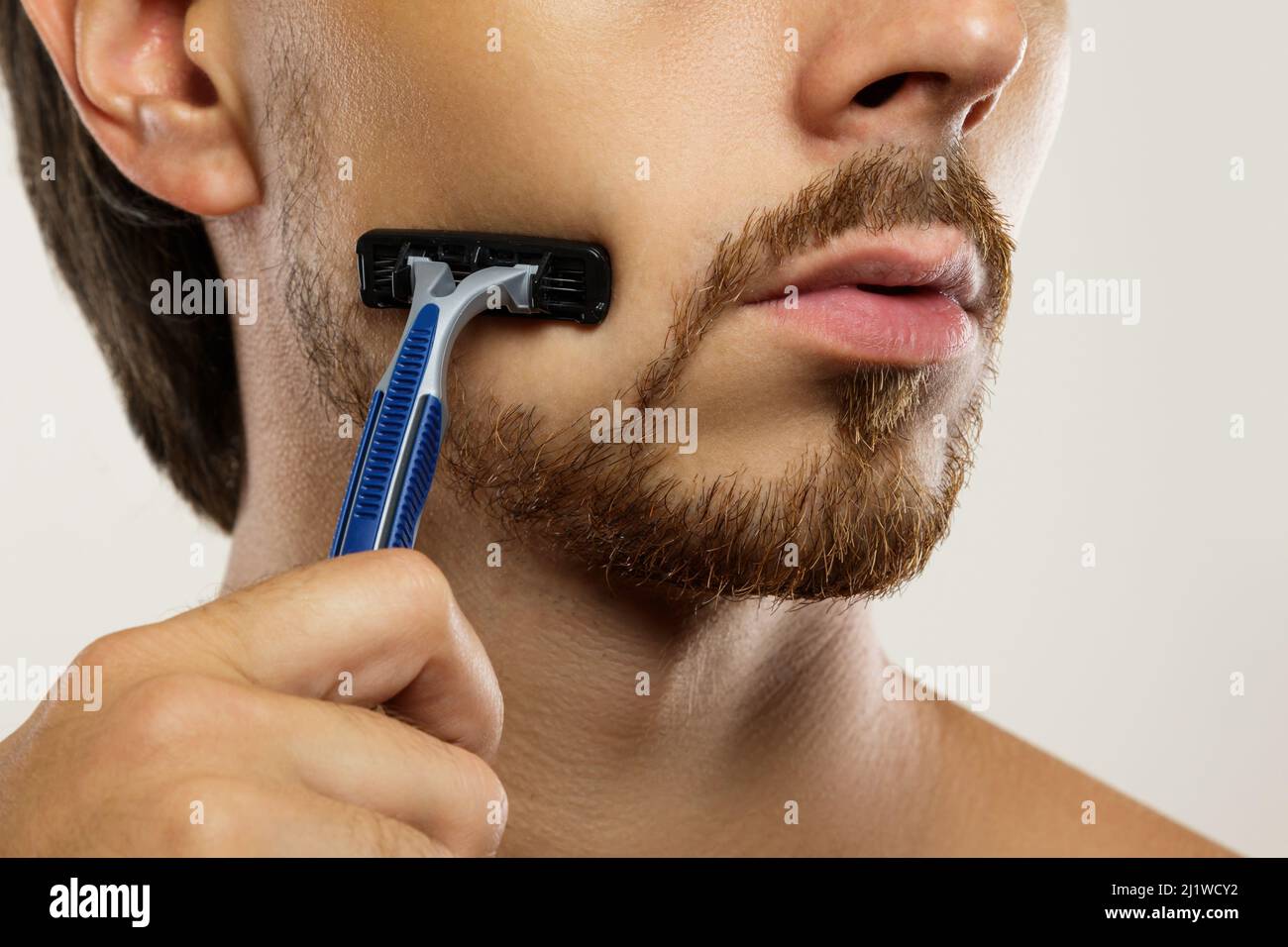 Man during shaving routine with a safety razor Stock Photo - Alamy