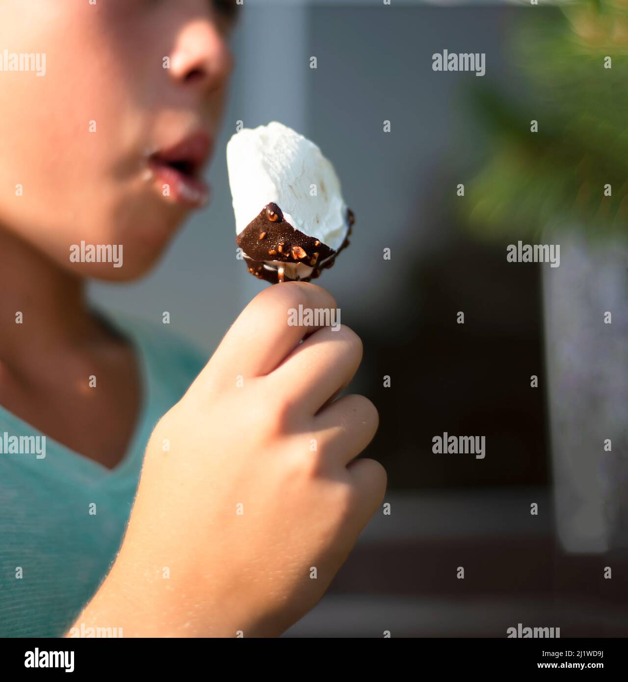 Eat ice cream. Eskimo in chocolate on a stick. Blurred face of a boy ...