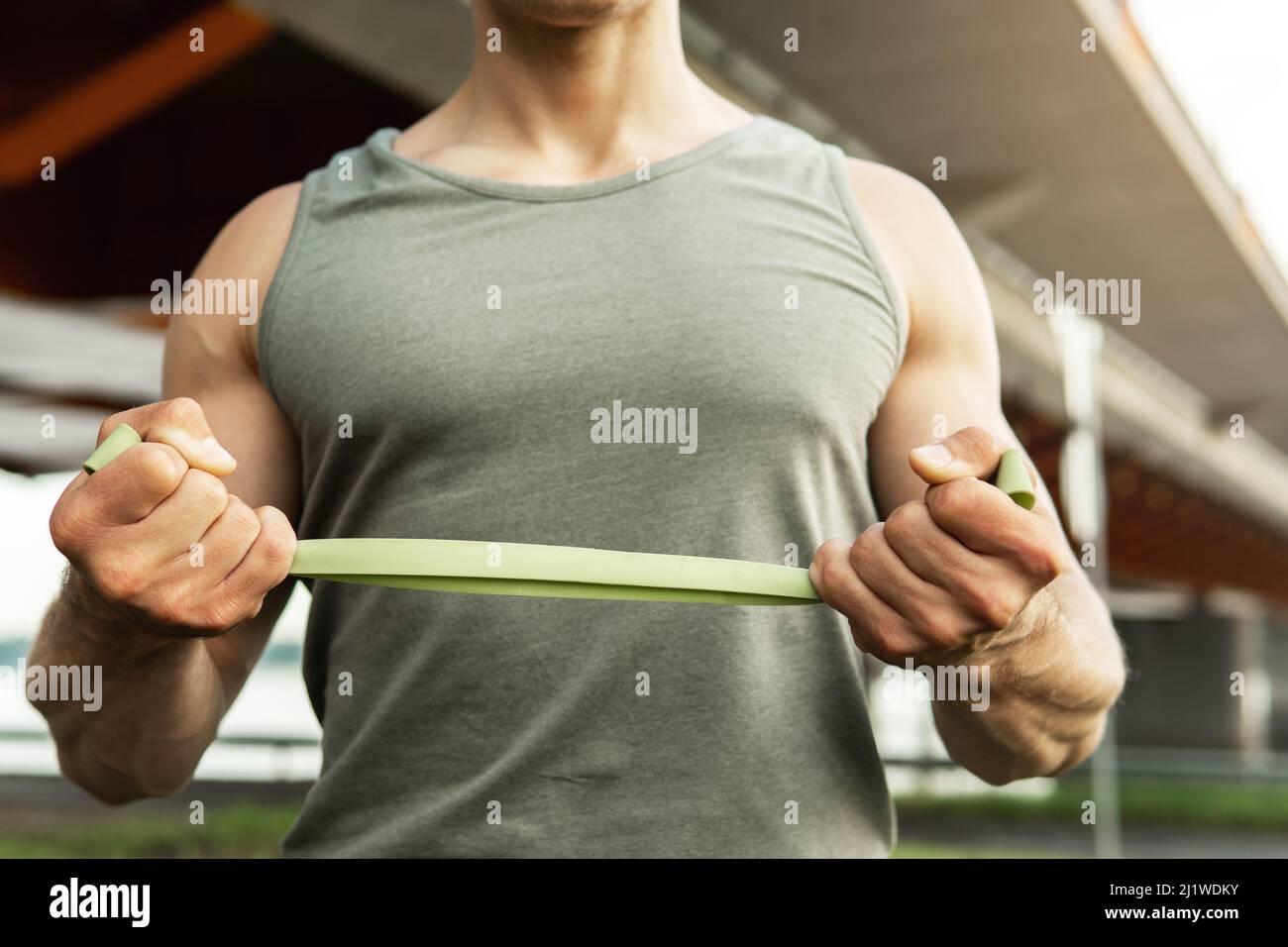 Man during workout with a resistance rubber bands outdoors Stock Photo ...