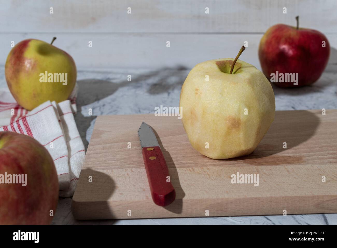 Peeled ripe red apple on a kitchen countertop, side view. Background ...