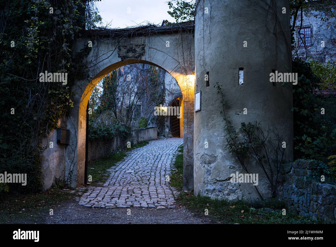 A narrow path through the old arches of a building Stock Photo - Alamy