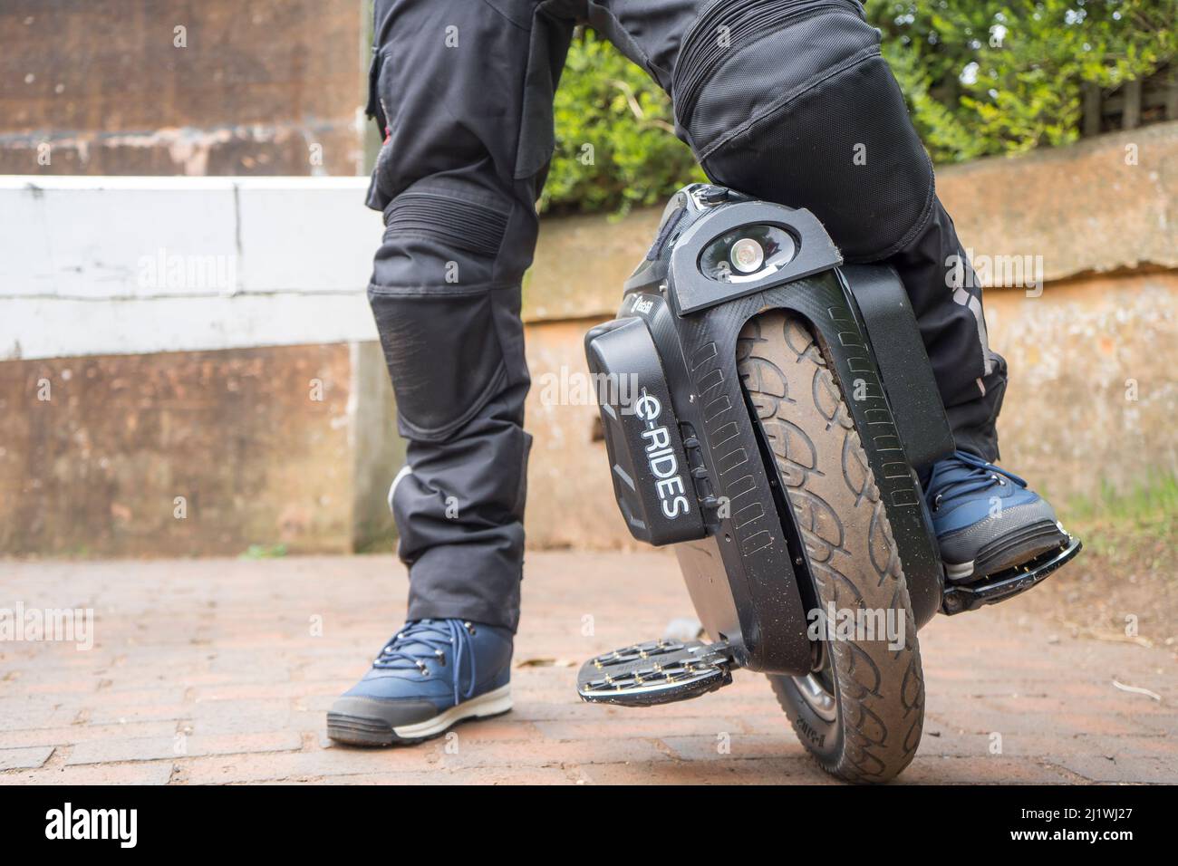 Close up of the legs & feet of an electric unicycle rider resting ...