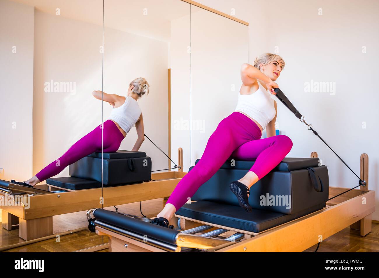 Woman is exercising on pilates reformer bed in her home Stock Photo - Alamy