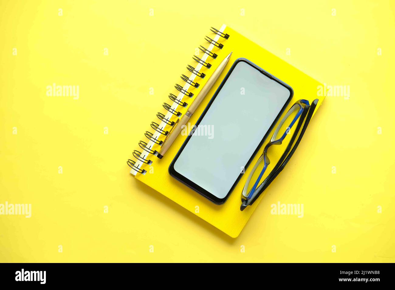 top view of smart phone and notepad on yellow background Stock Photo ...
