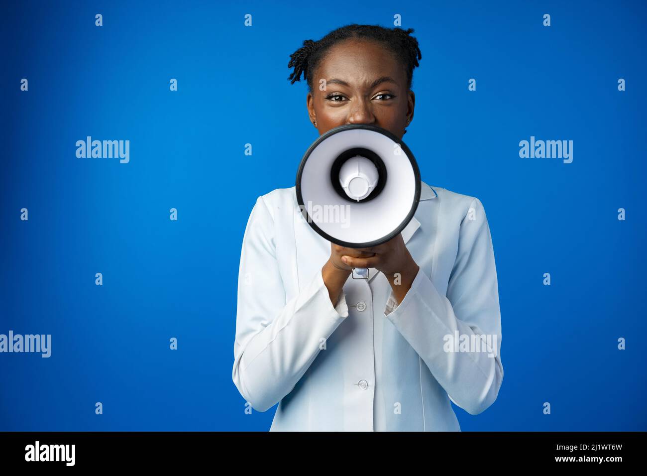 Afro american female doctor in white medical gown scream in megaphone ...