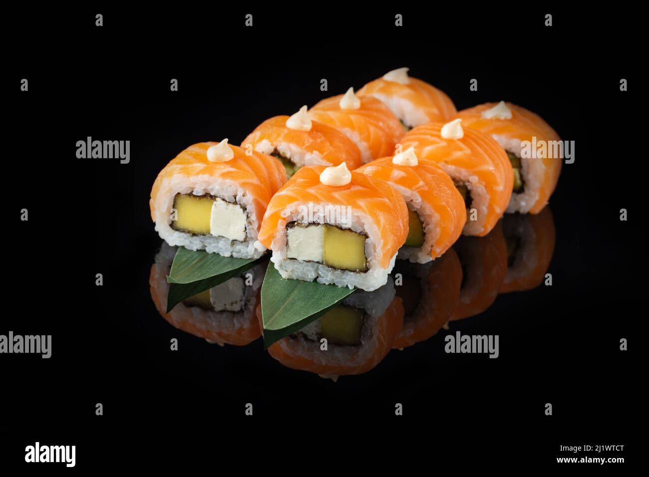Traditional delicious fresh sushi roll set on a black background with ...
