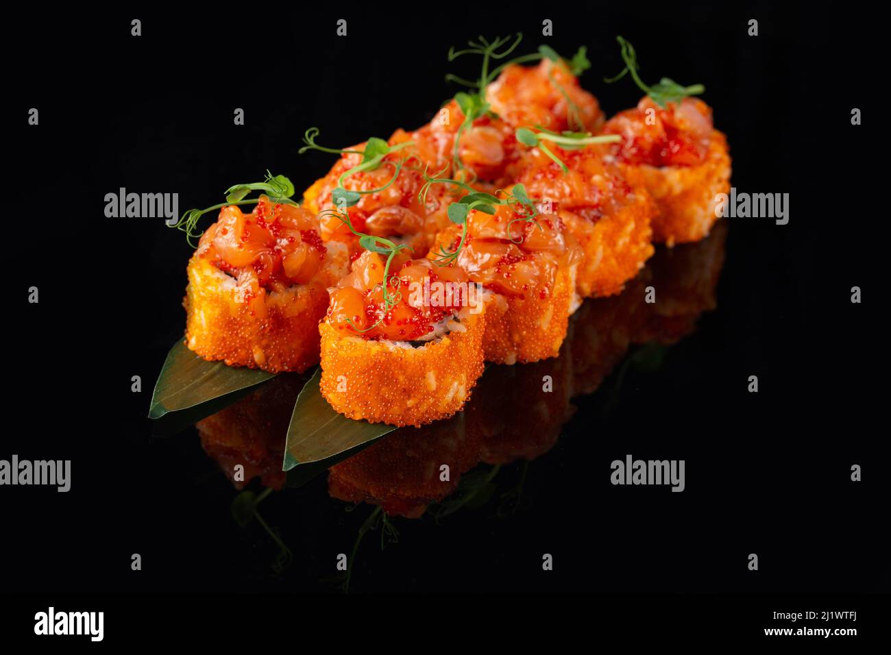 Traditional delicious fresh sushi roll set on a black background with ...