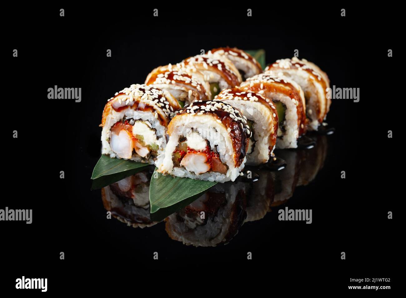 Traditional delicious fresh sushi roll set on a black background with ...