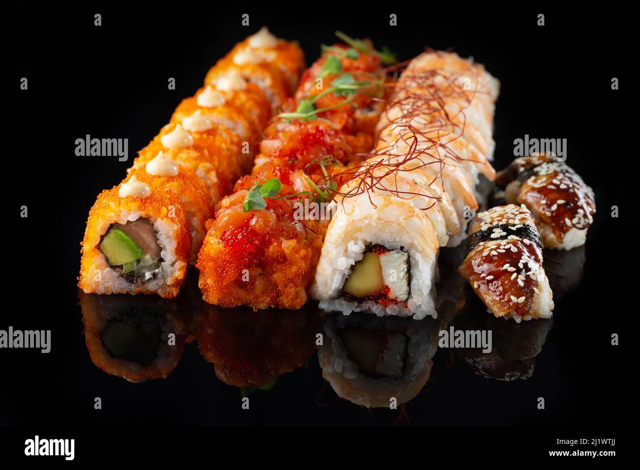 Traditional delicious fresh sushi roll set on a black background with ...