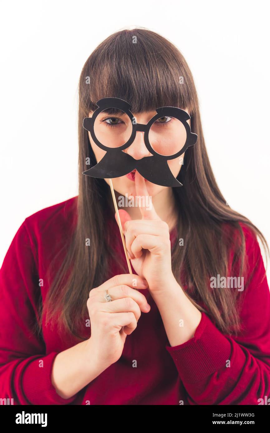 Vertical studio shot of a young caucasian brunette shushing while ...