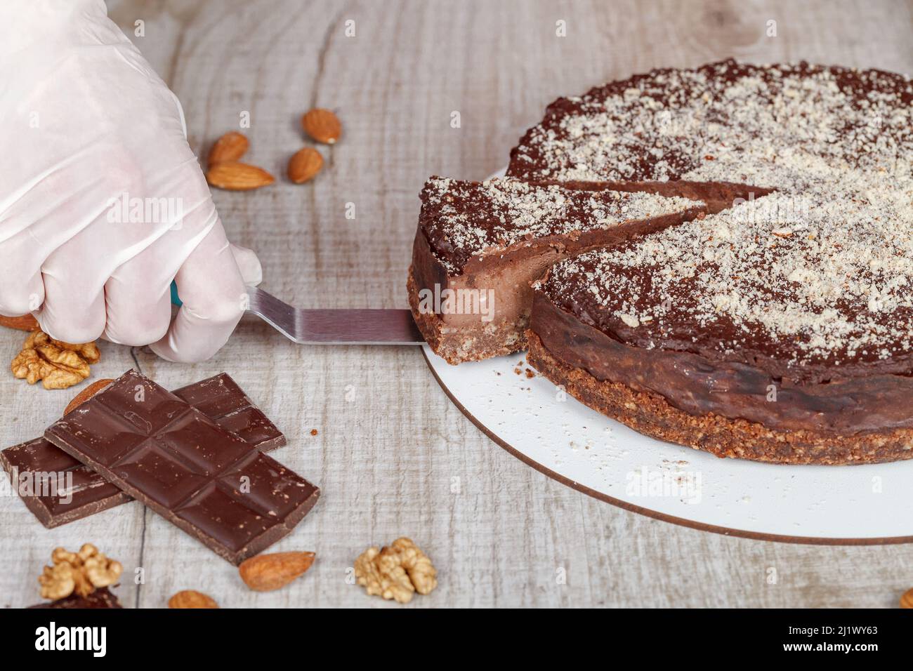 Chocolate cake with a cut piece and blade on gray background, closeup ...