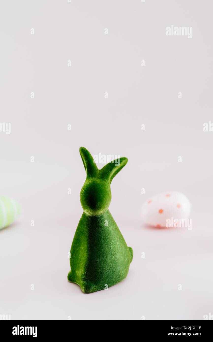Green bunny rabbit figurine and colored easter eggs in different ...