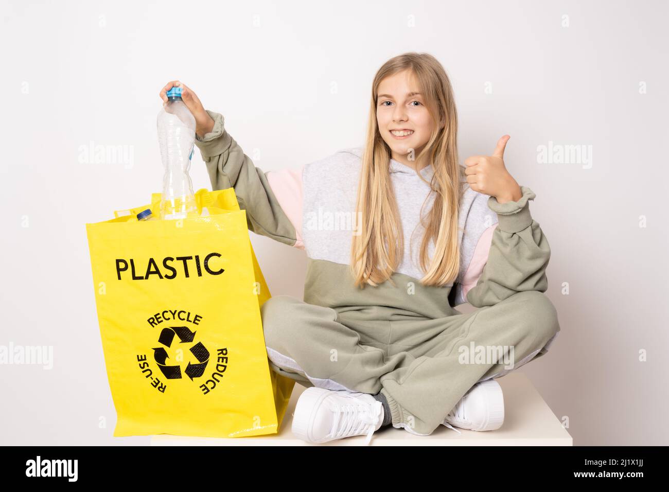 Smiling girl with an ecological bag isolated over a white background ...