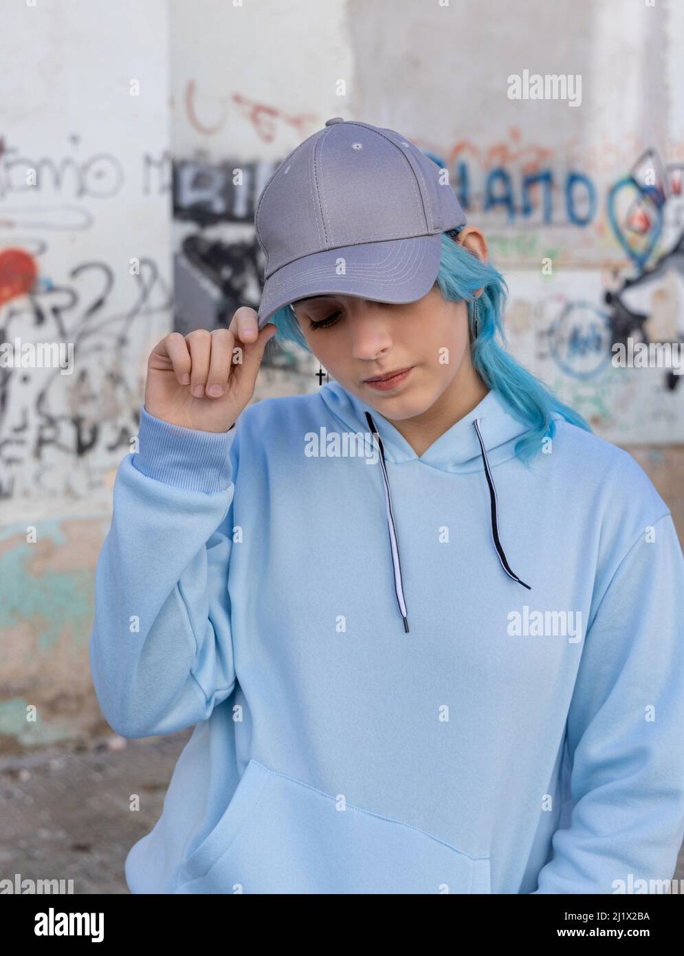 Blue haired Teenage girl in blue hoodie and baseball cap with closed ...