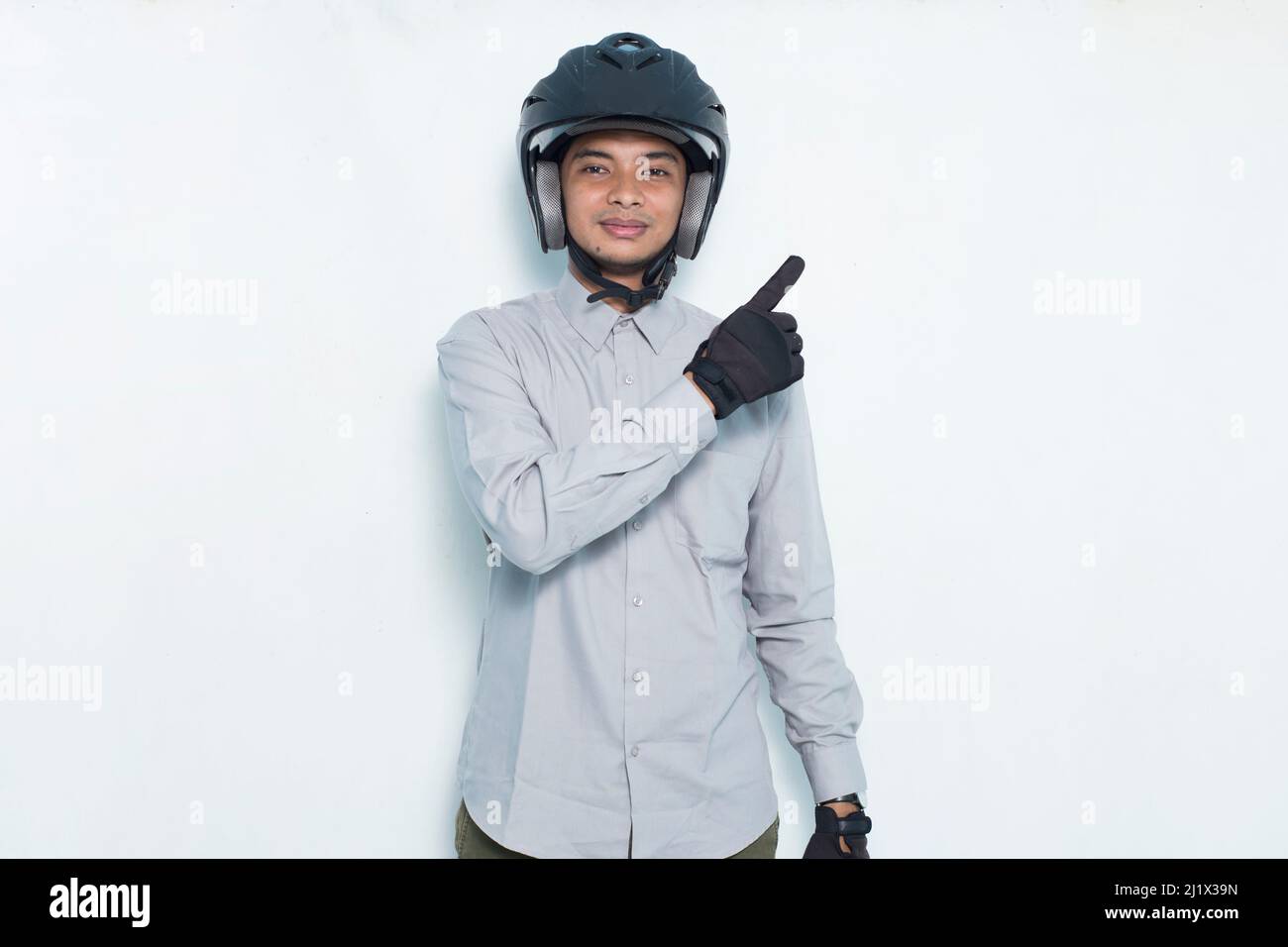 handsome asian man with a motorcycle helmet pointing with fingers to ...