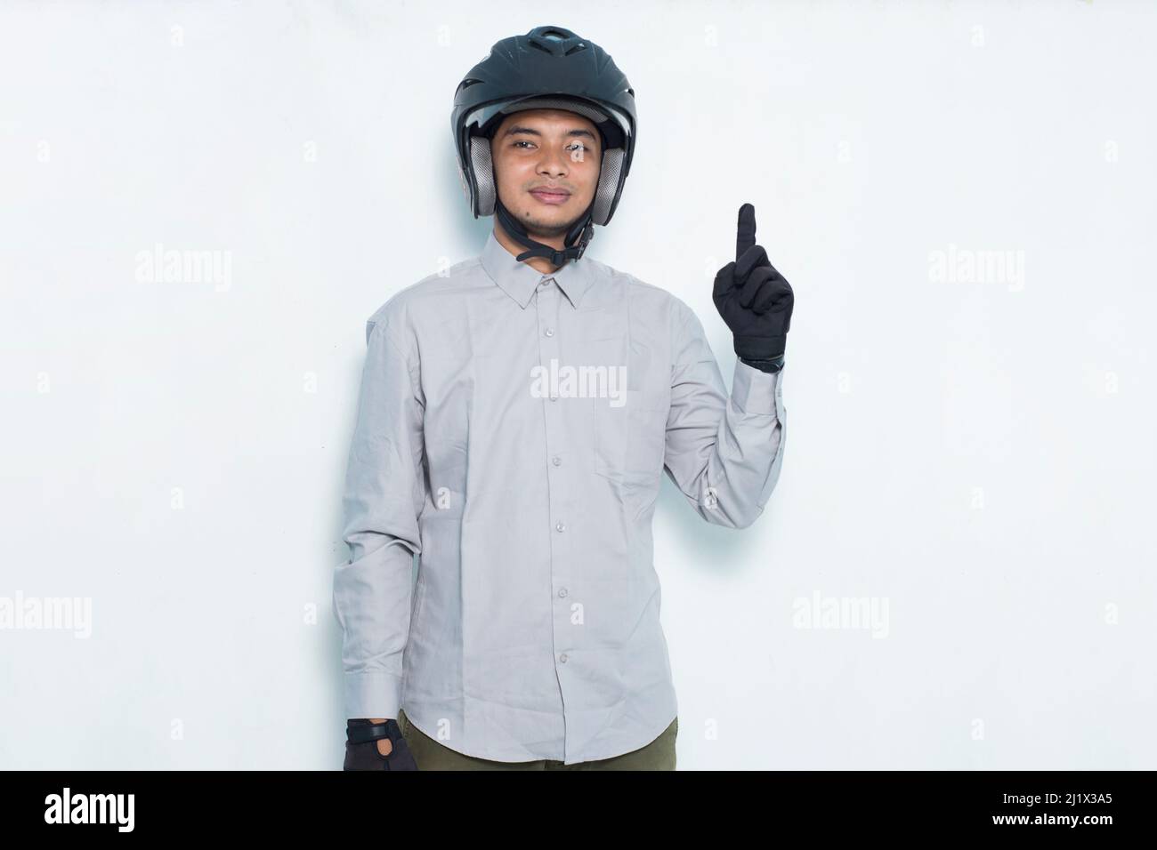 handsome asian man with a motorcycle helmet pointing with fingers to ...
