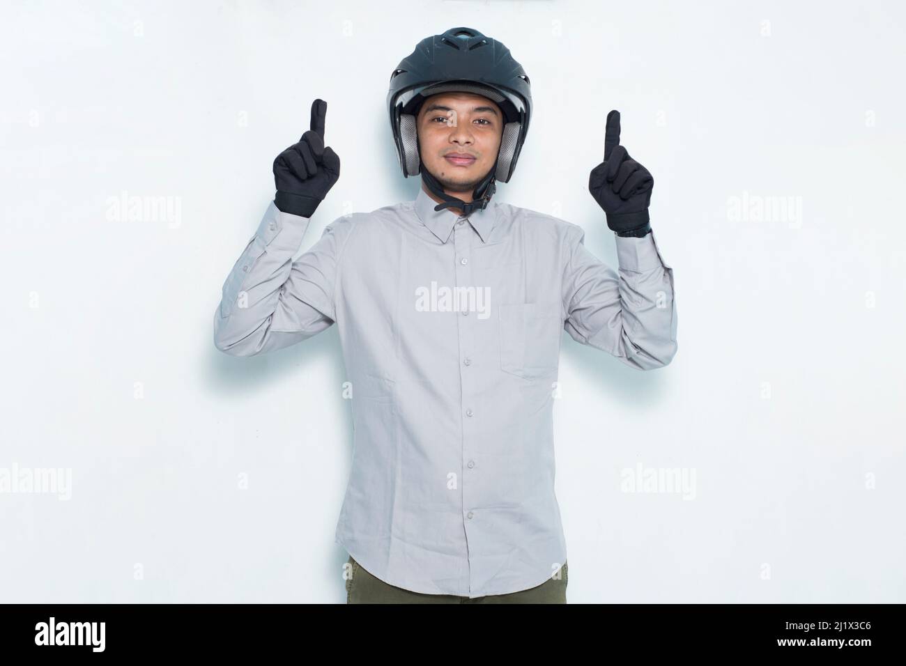 handsome asian man with a motorcycle helmet pointing with fingers to ...