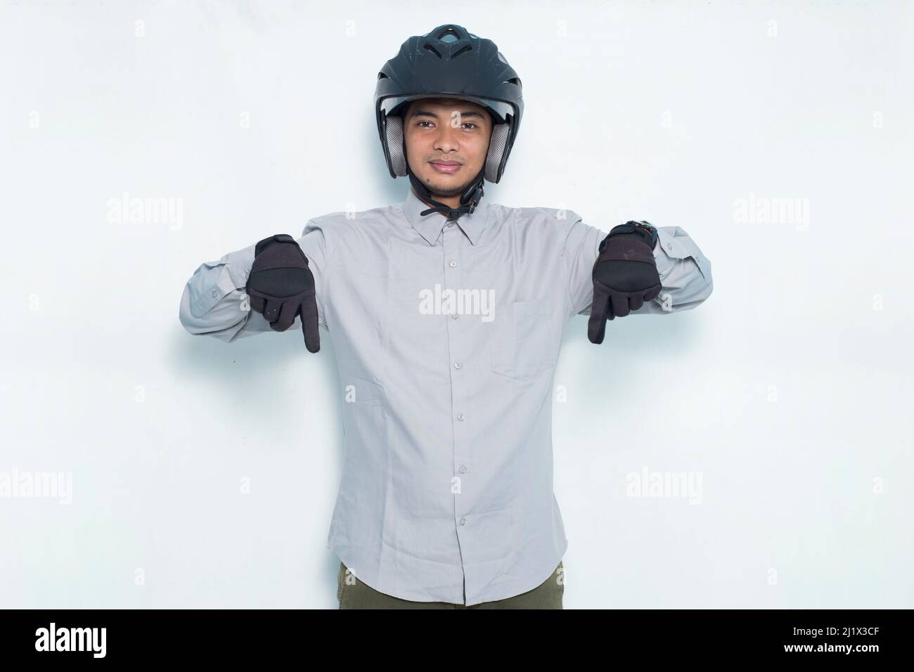 handsome asian man with a motorcycle helmet pointing with fingers to ...
