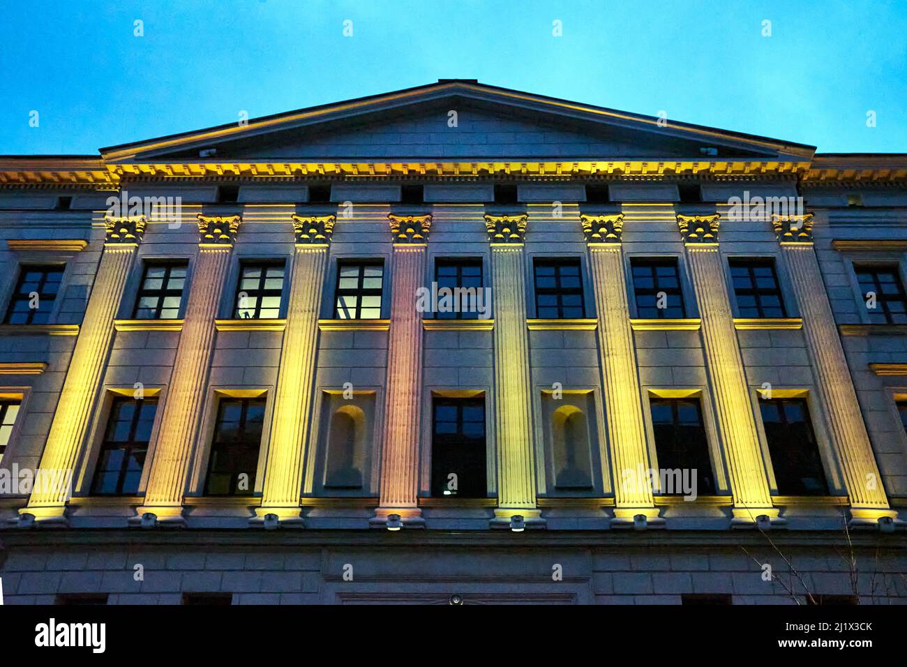 The facade of a historic neoclassical building in the evening in Poznan ...