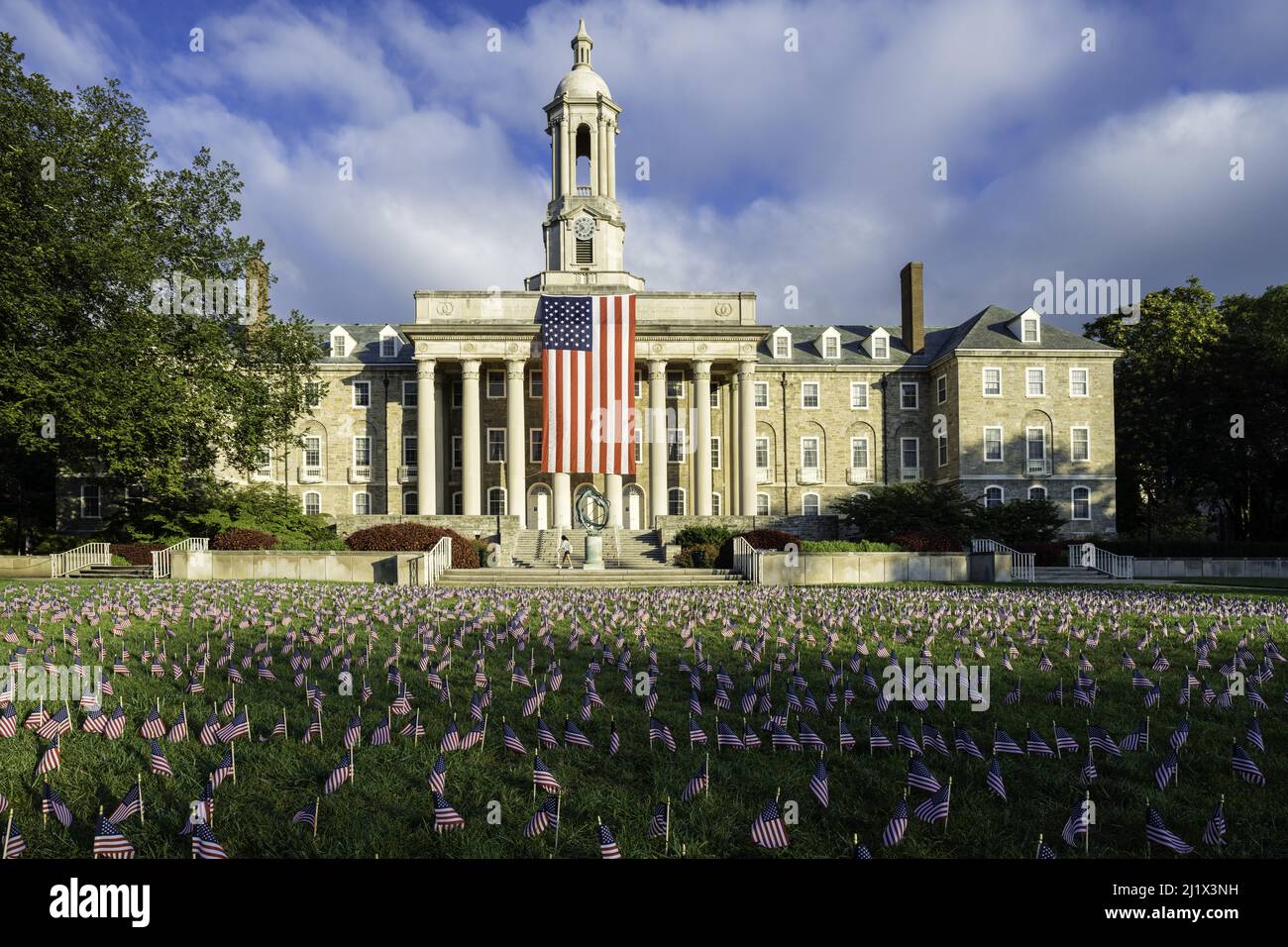 A scenic view of the Old Main building with the flag of the USA on the ...