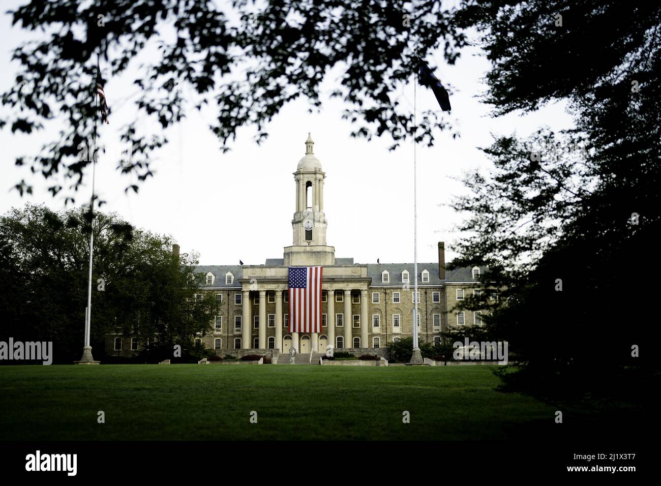A scenic view of the Old Main building with the flag of the USA on the ...