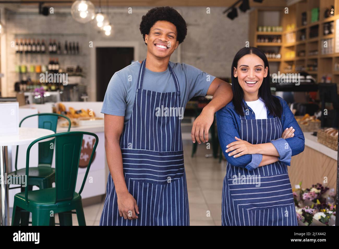 Portrait of confident multiracial baristas wearing aprons standing at ... Portrait of confident multiracial baristas wearing aprons standing at ...