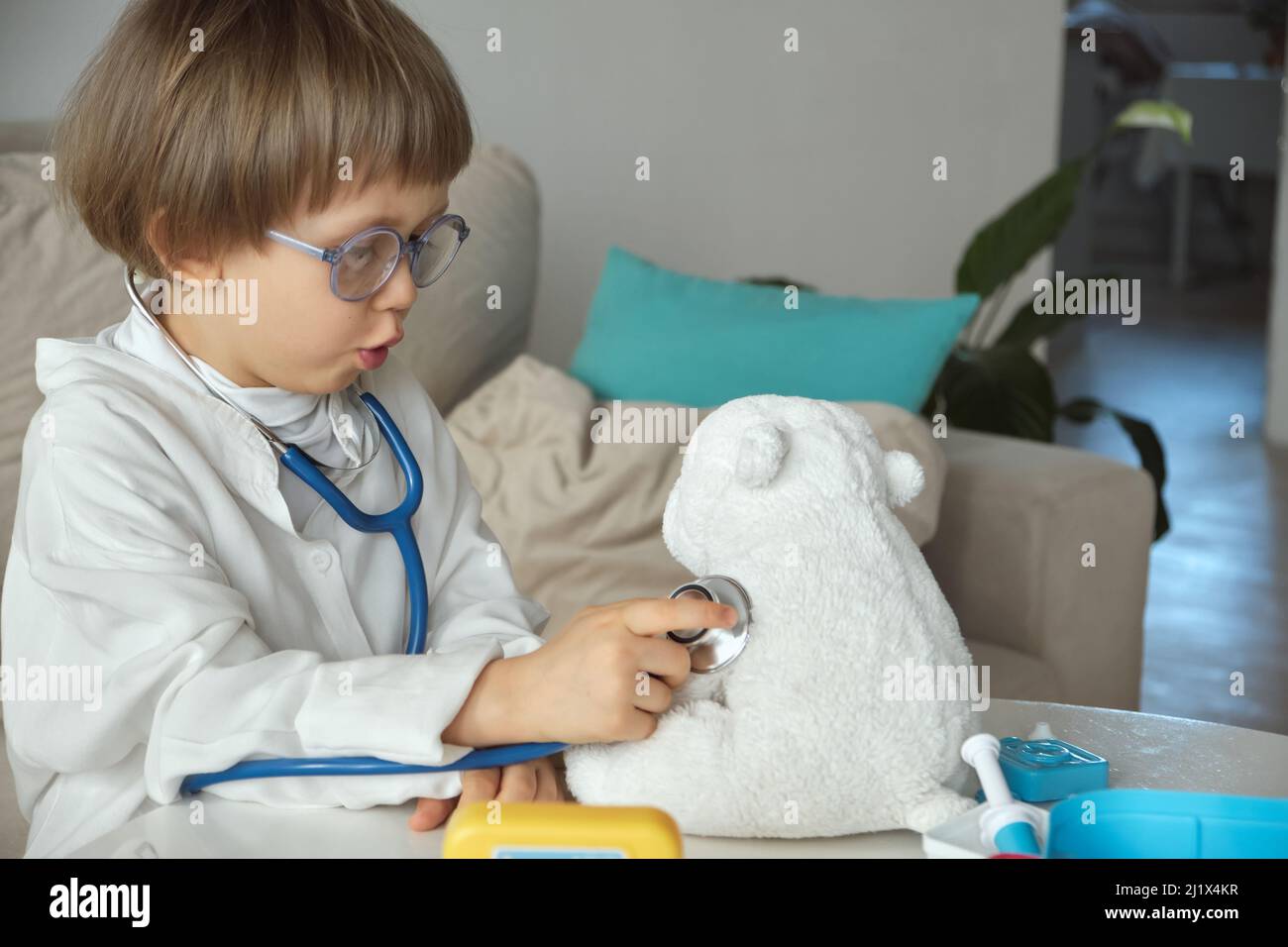 Little doctor in medical coat with stethoscope play an examination of ...