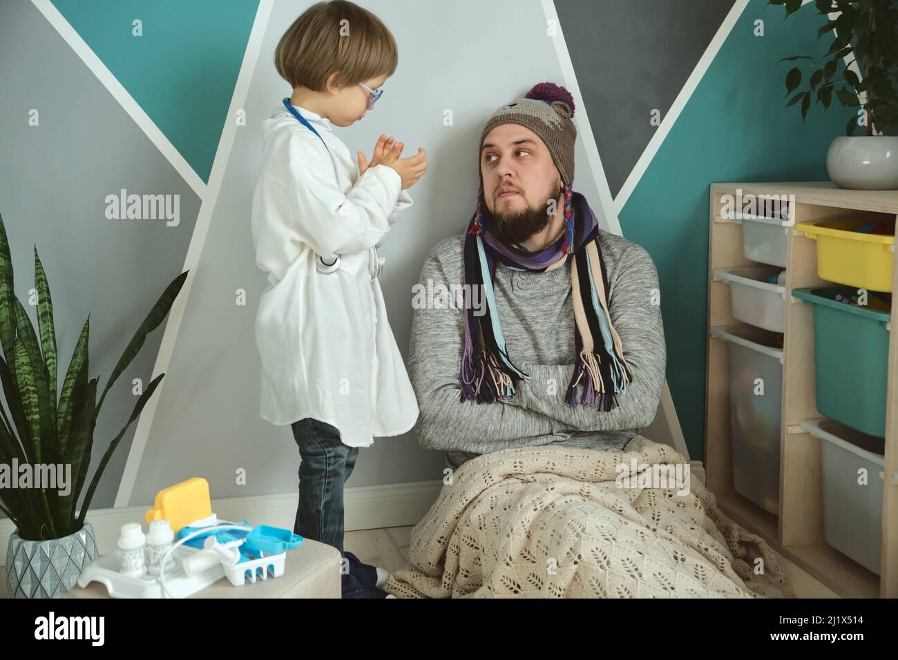 Father and child playing clinic and doctor, little boy in medical gown ...