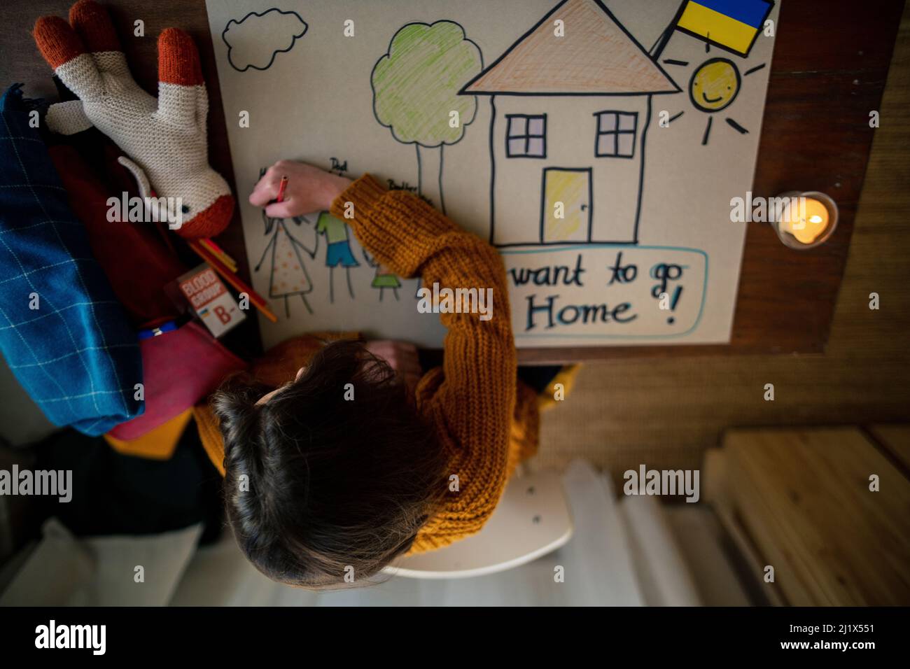 Top view of Ukrainian refugee schoolgirl missing home and drawing her ...