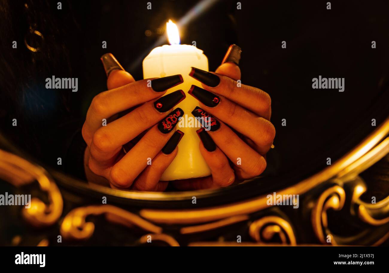 A mirror reflection of a candle burning in a woman's hands Stock Photo ...