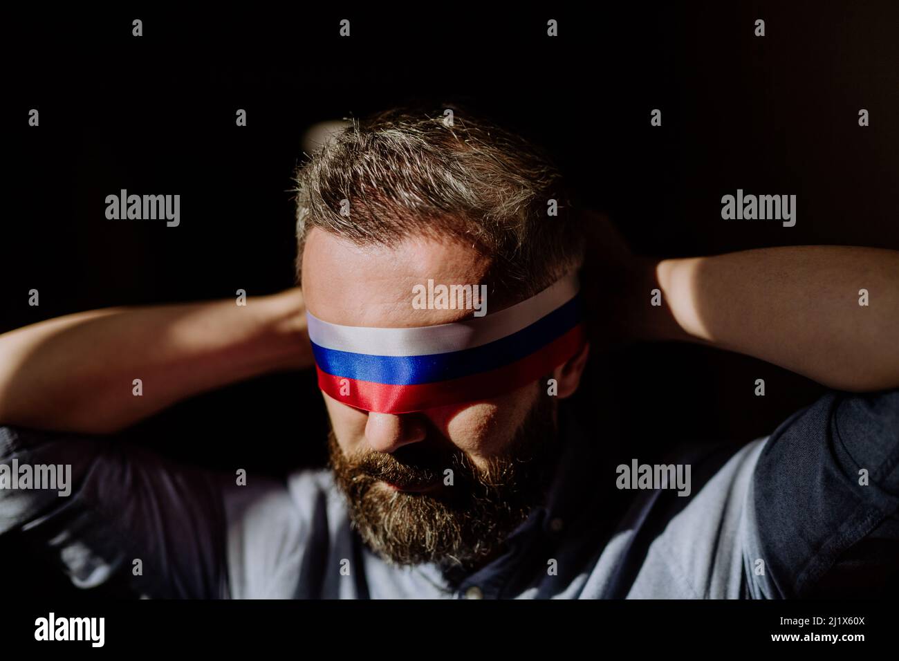 Man with Russian flag blindfold on black background, Russian propaganda ...