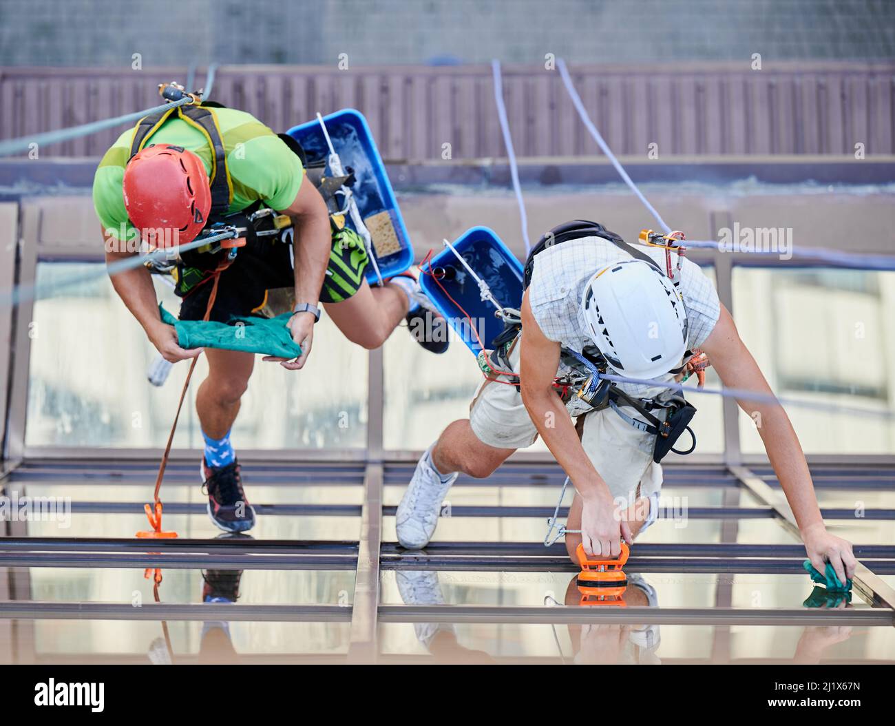 Industrial mountaineering. Top view of professional cleaners hanging on ...