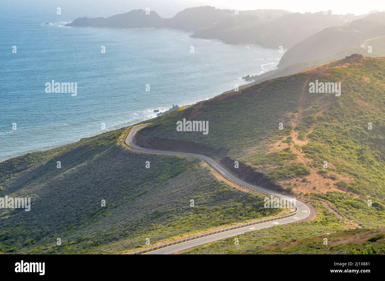 Empty wnding coast road at sunset Stock Photo - Alamy