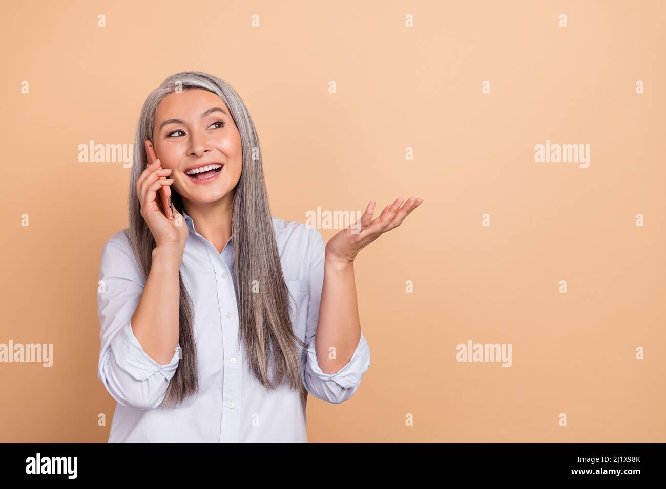 Photo of cheerful mature woman talk mobile listen communication look ...