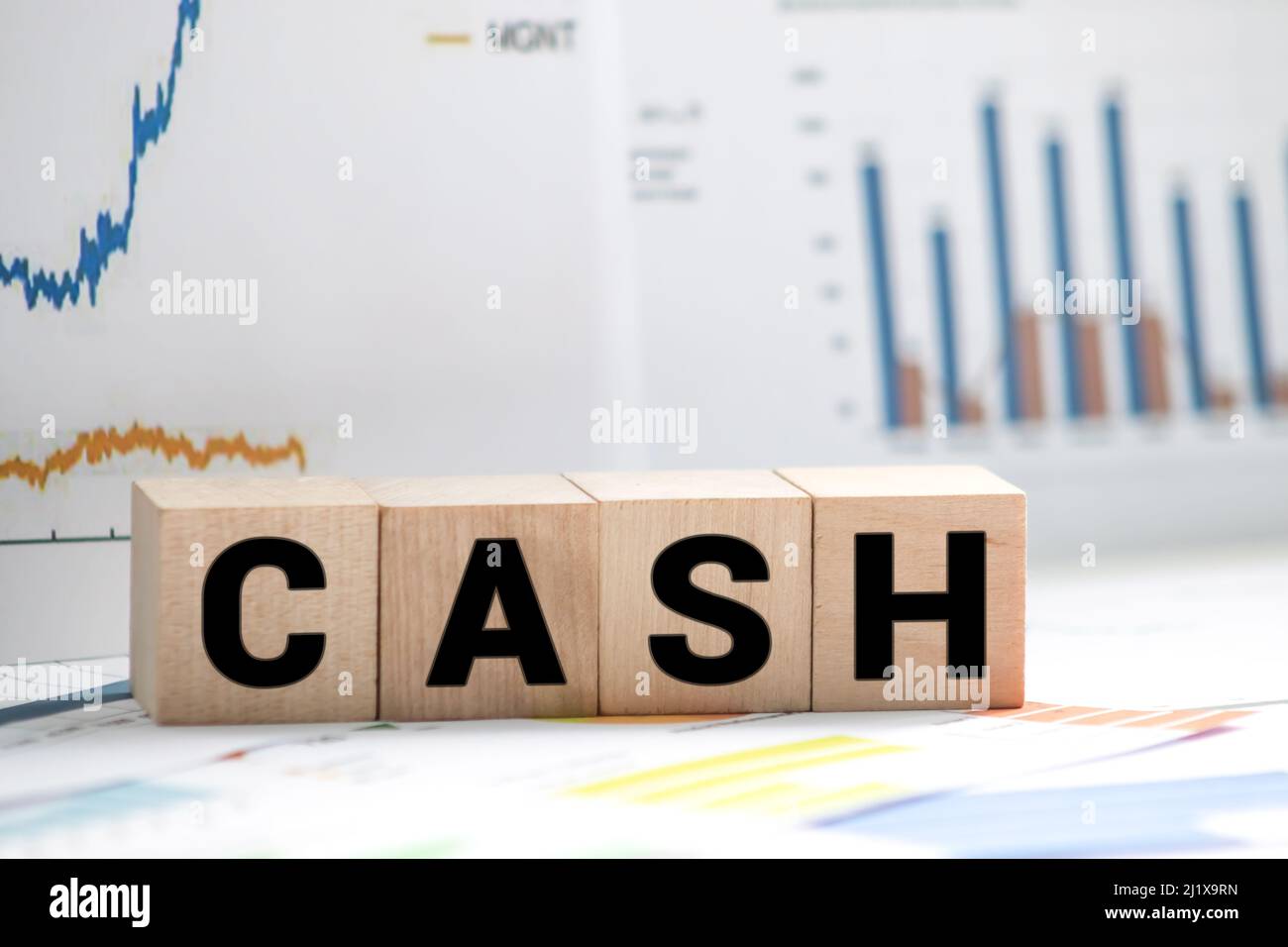 CASH word concept written on wooden cube blocks lying on a light table ...