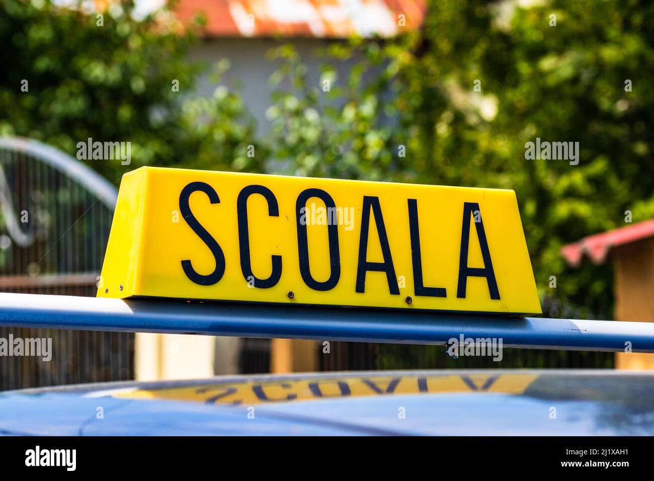 Driving school sign placed on top of car Stock Photo - Alamy