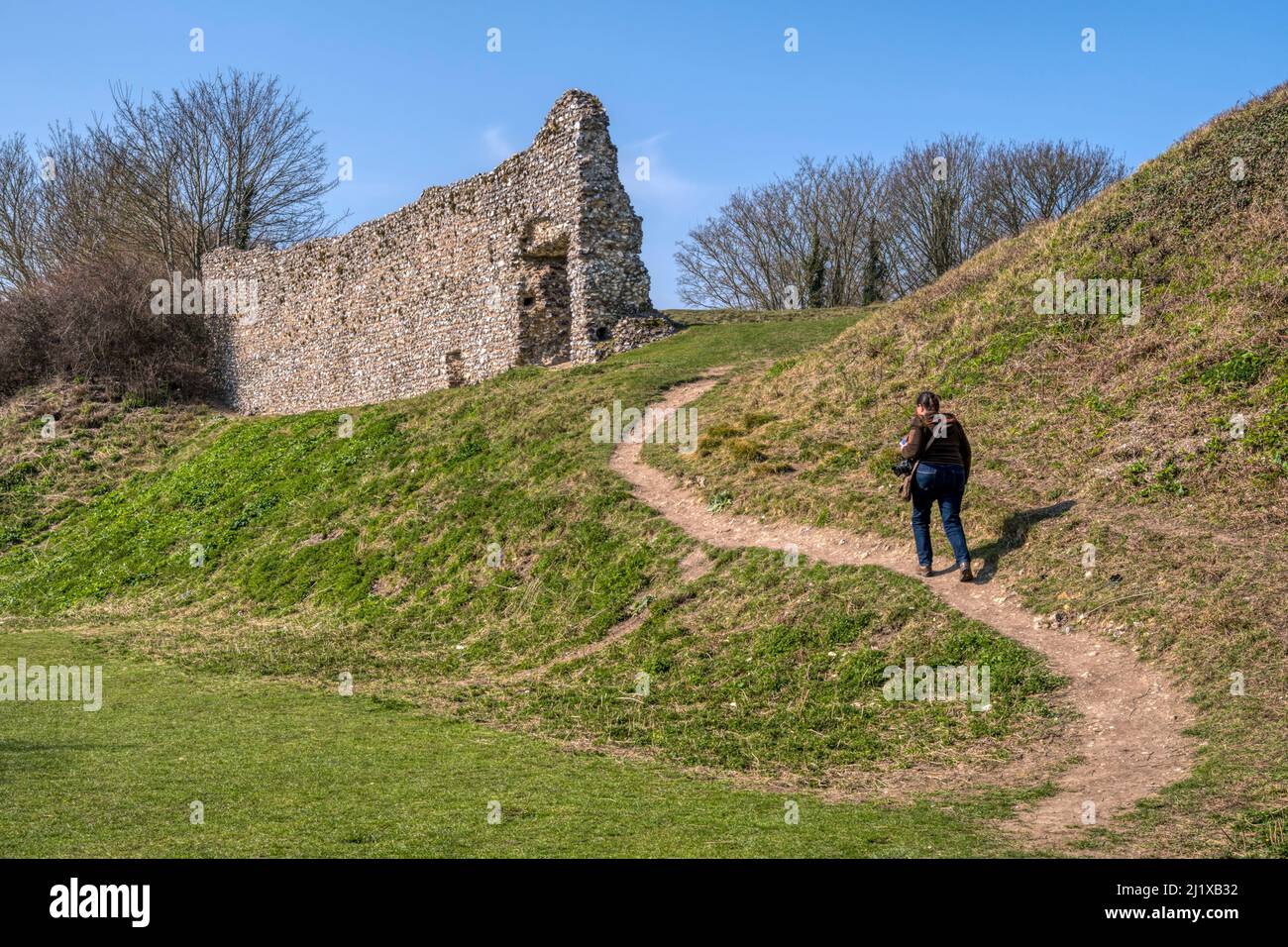Woman walking up a path to the outer bailey of Castle Acre Castle Stock ...