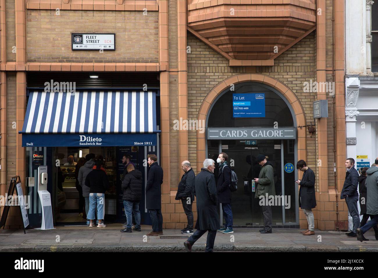 People queue outside a sandwich bar in London, at lunch hour, as work ...