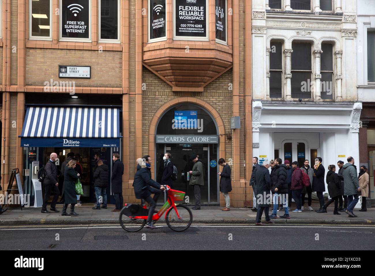 People queue outside a sandwich bar in London, at lunch hour, as work ...