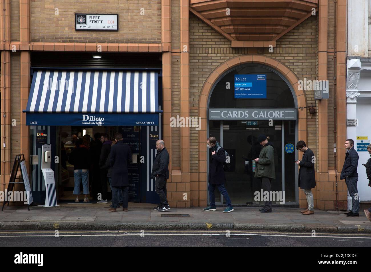 People queue outside a sandwich bar in London, at lunch hour, as work ...