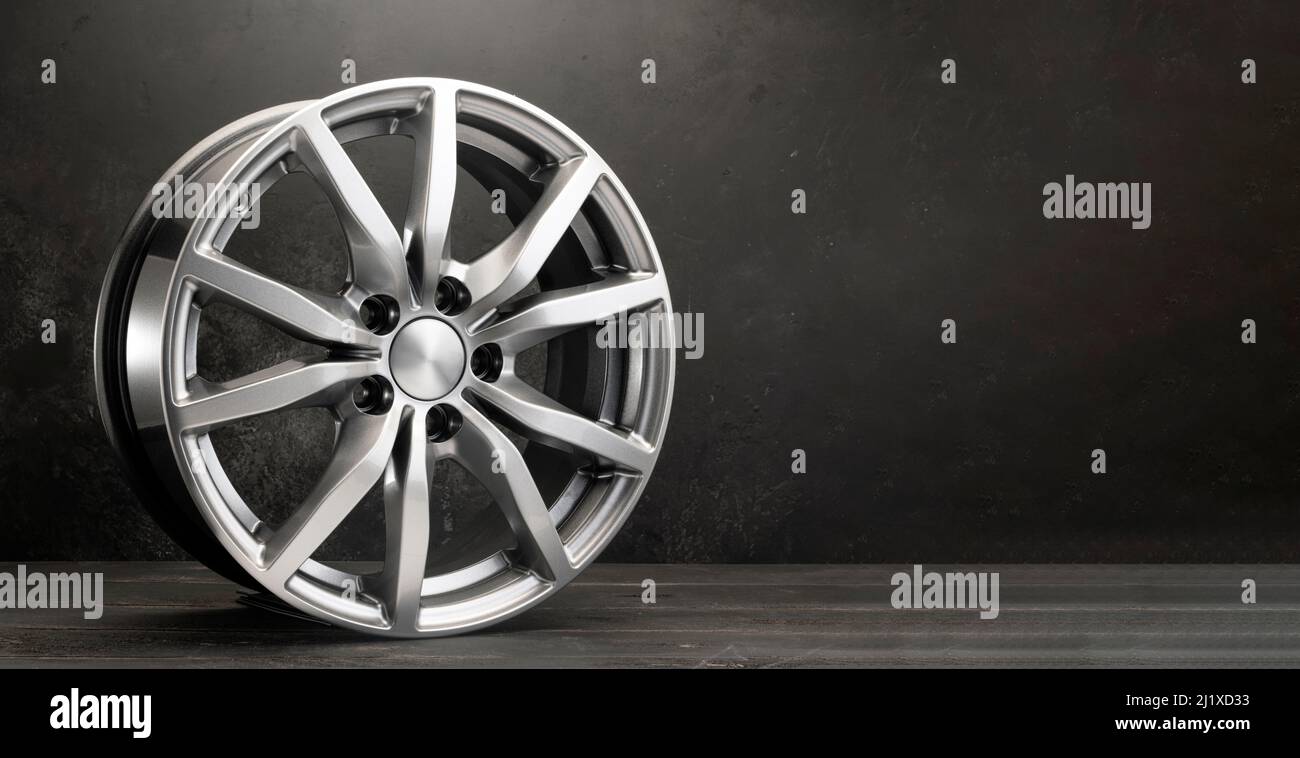 new grey alloy wheels on a dark textured black background. car wheel ...