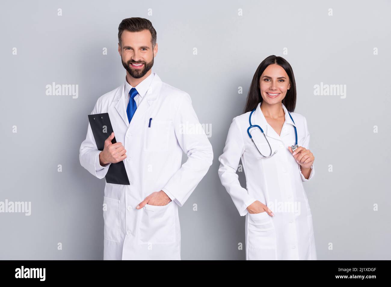 Photo of smart clever two docs dressed white coats holding clipboard ...