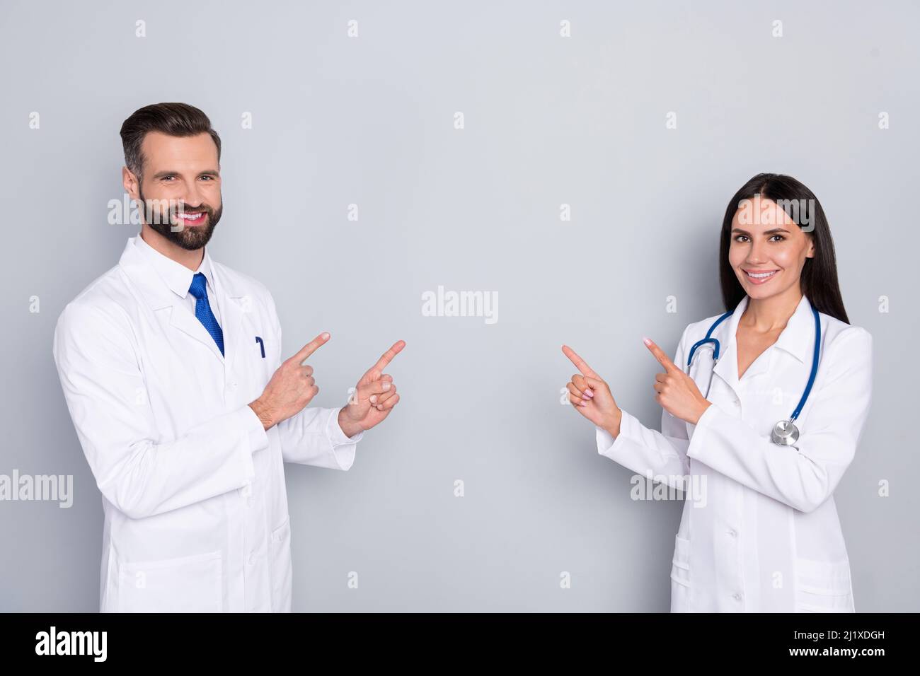 Portrait of two attractive cheerful medics demonstrating therapy copy ...