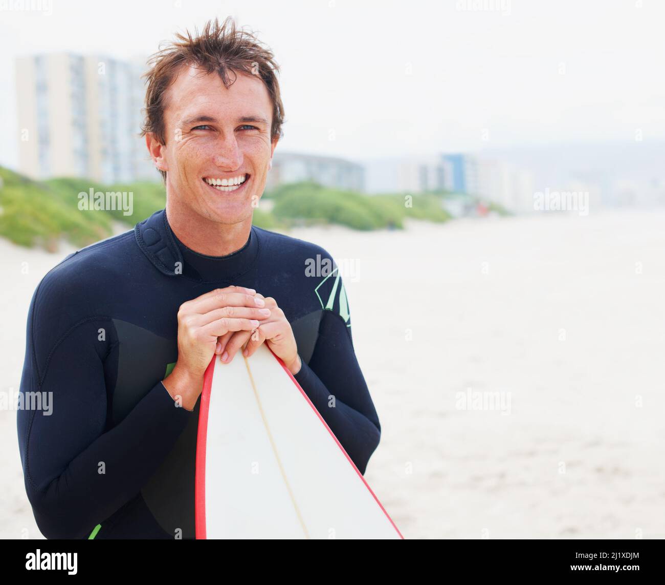 Feeling great after an epic session. A surfer posing on the beach with ...